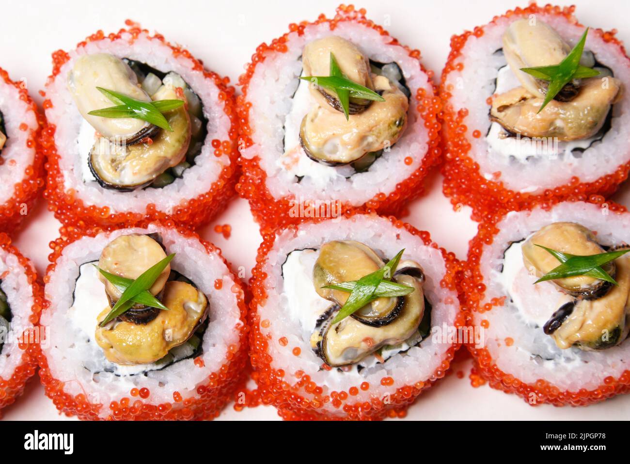 Elite sushi on a white background in red tobiko caviar with mussels on ...