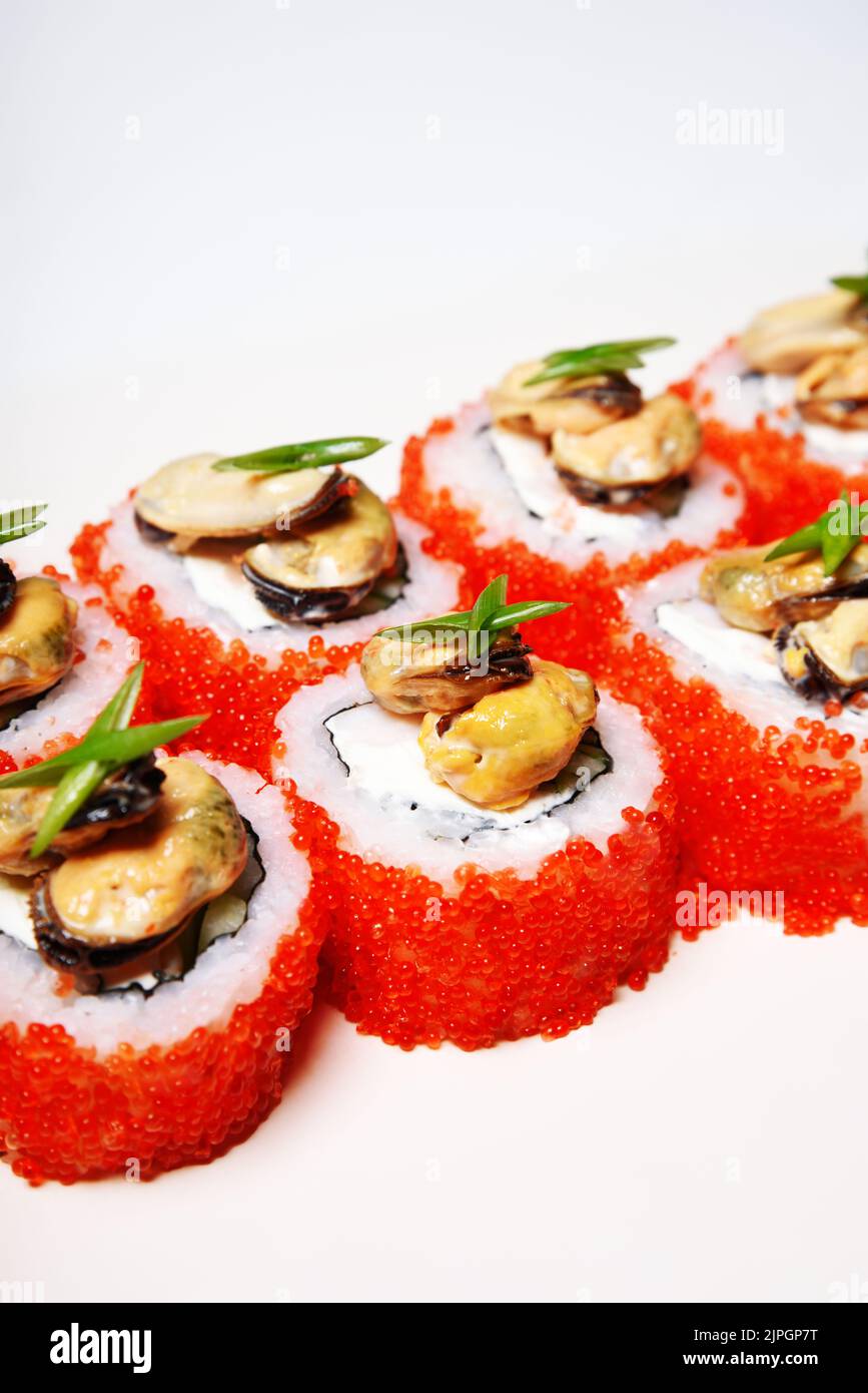 Elite sushi on a white background in red tobiko caviar with mussels on ...