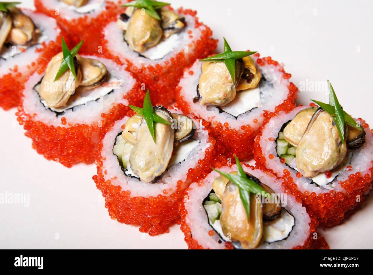Elite sushi on a white background in red tobiko caviar with mussels on ...
