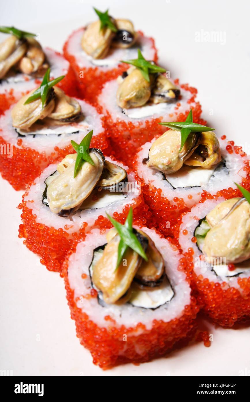 Elite sushi on a white background in red tobiko caviar with mussels on ...