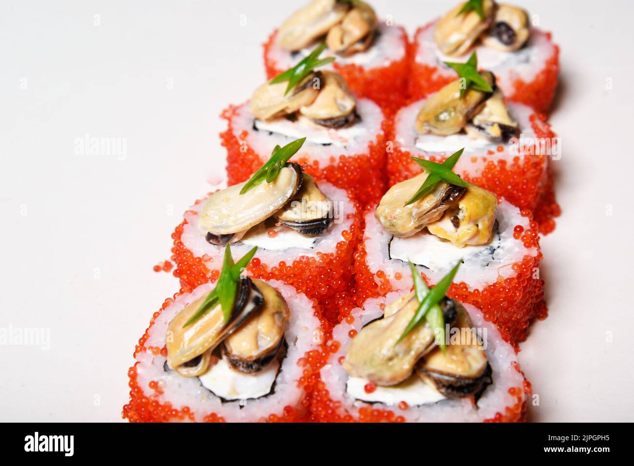 Elite sushi on a white background in red tobiko caviar with mussels on ...