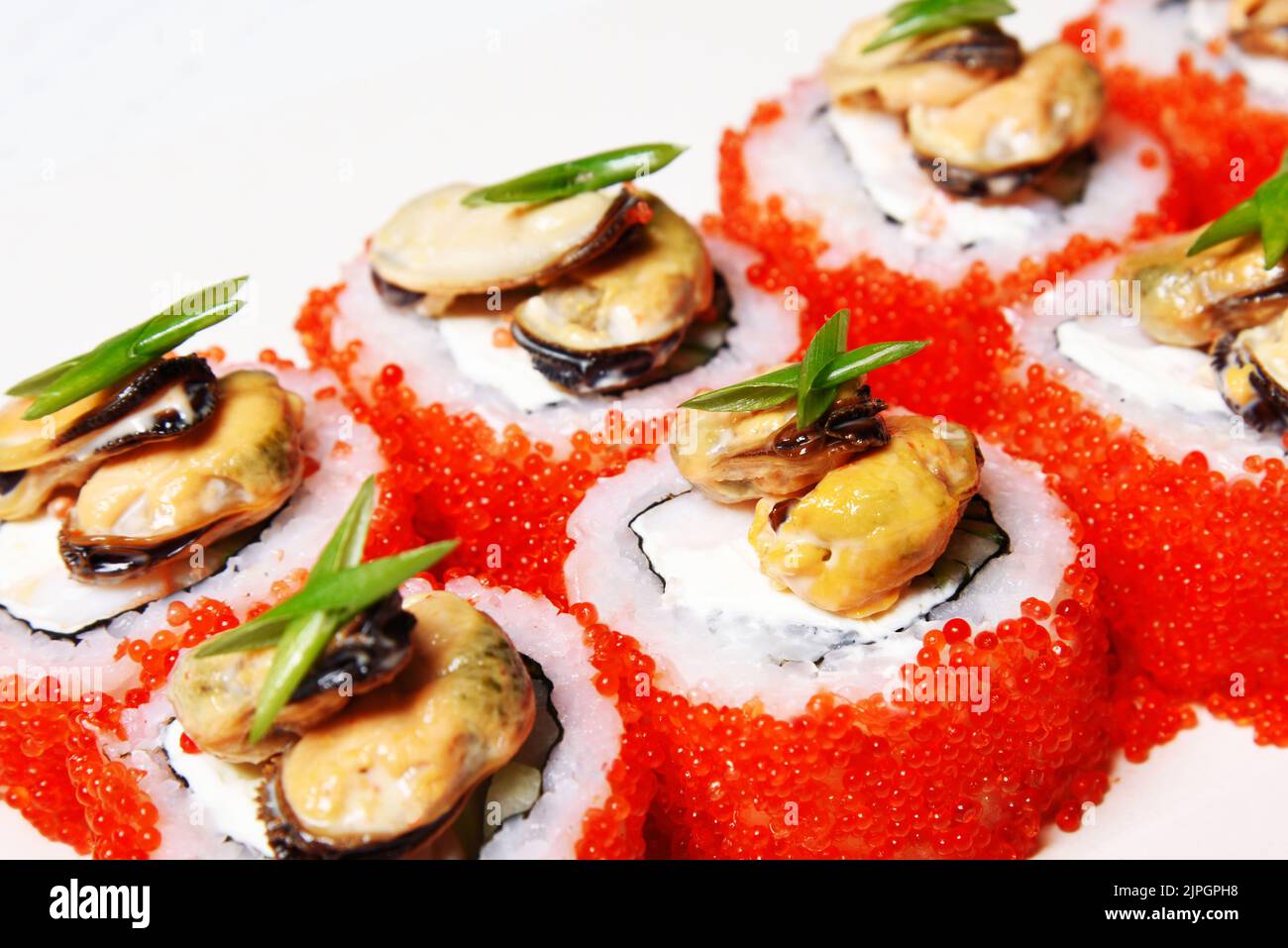 Elite sushi on a white background in red tobiko caviar with mussels on ...