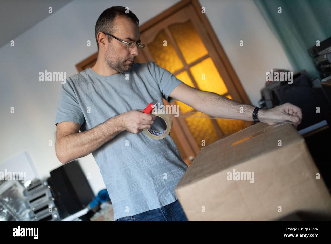 Adult man small business owner packing order box package shipping to ...