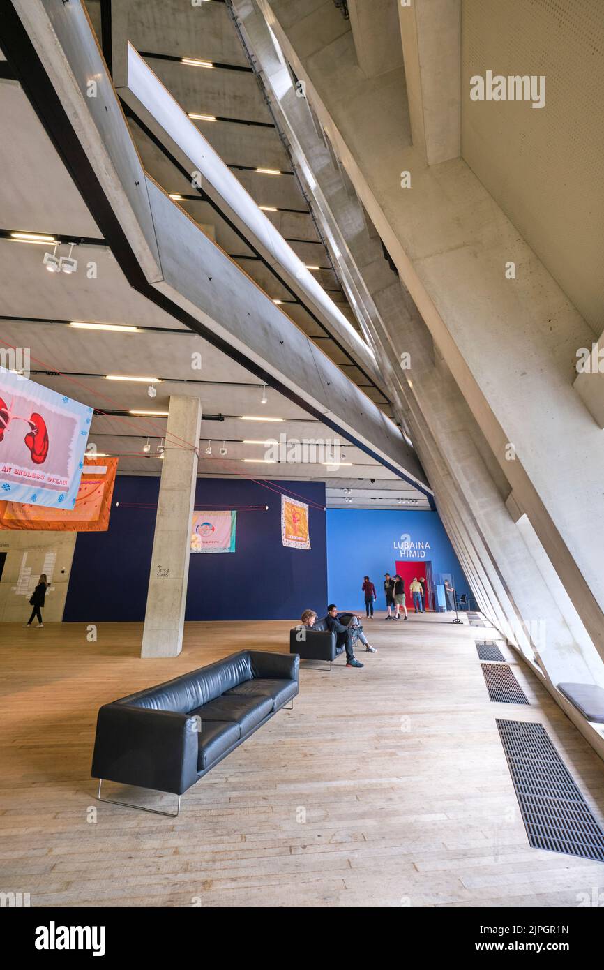 The atrium with a soaring wall of windows in unfinished concrete ...