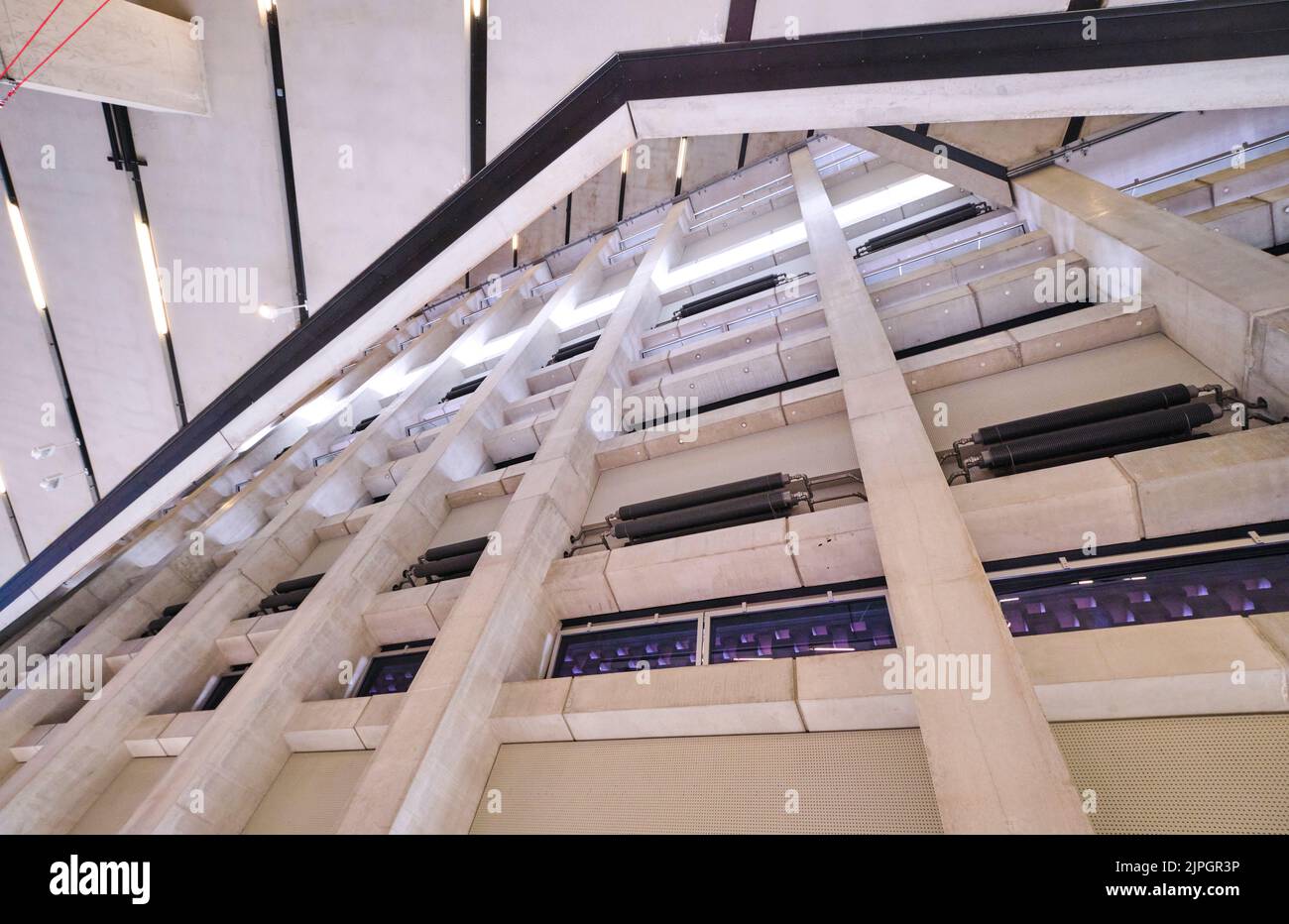 The raw, unfinished concrete window framing in the soaring atrium. In ...
