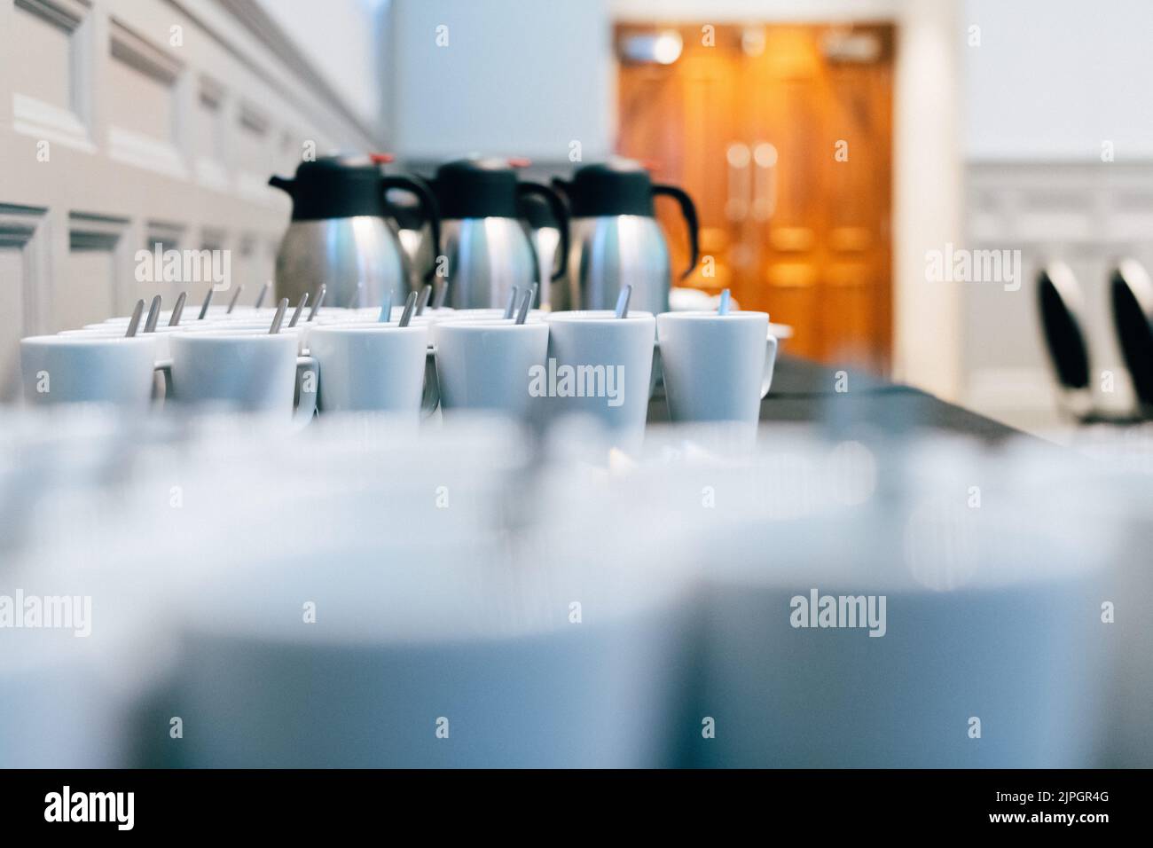 A Conference Room Table with Empty Tea Mugs and Coffee Thermoses Stock ...