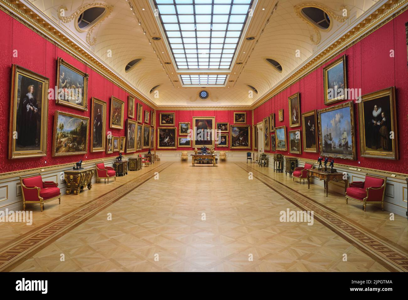 Interior view of the large, red wallpaper salon with many Old Master ...
