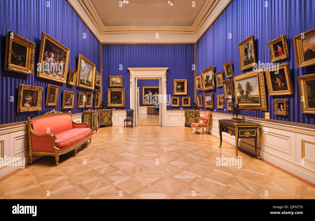 Old Master paintings hang on the wall in a gallery with bright blue ...