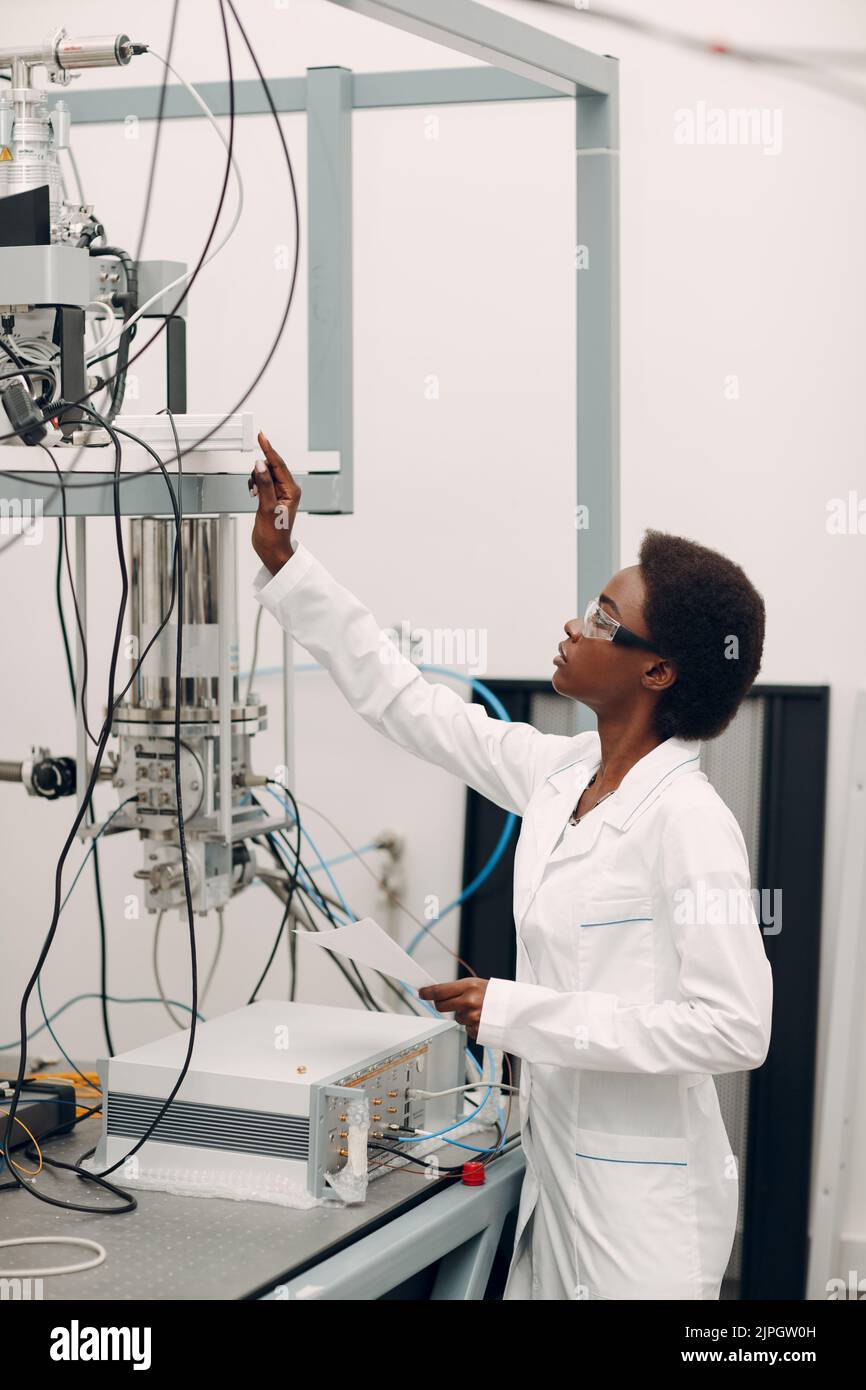 Scientist african american woman working in laboratory with electronic tech single photon ...