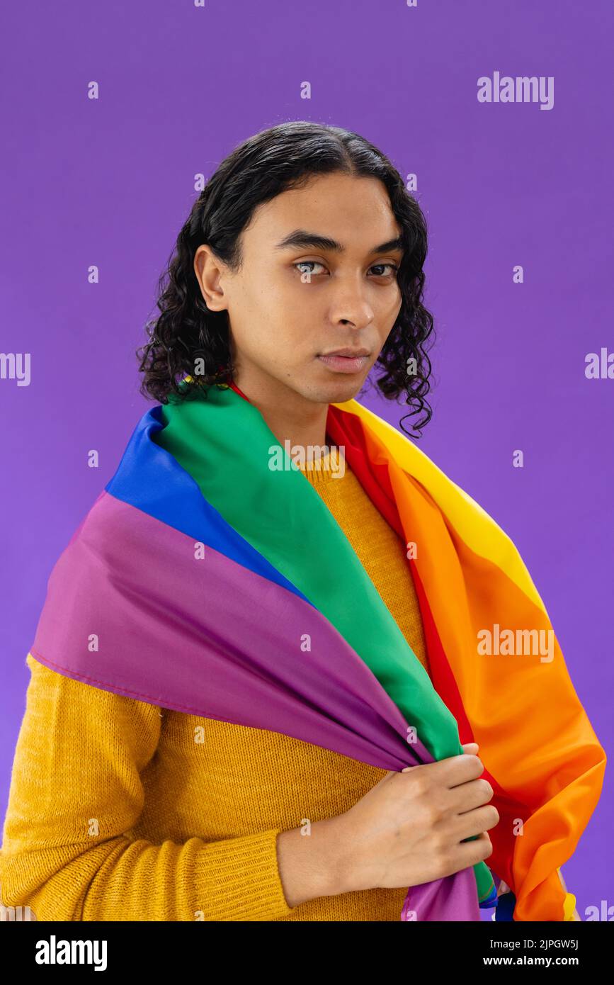 Portrait of happy biracial man holding lgbt rainbow flag and smiling on ...