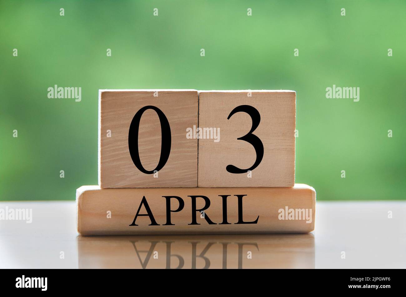 April 3 calendar date text on wooden blocks with blurred park ...