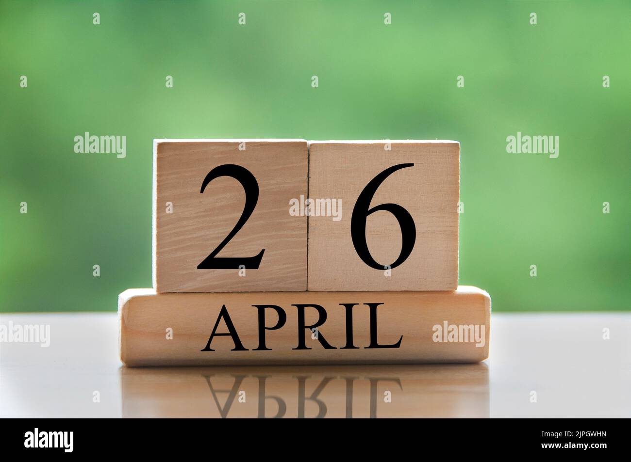 April 26 calendar date text on wooden blocks with blurred park ...