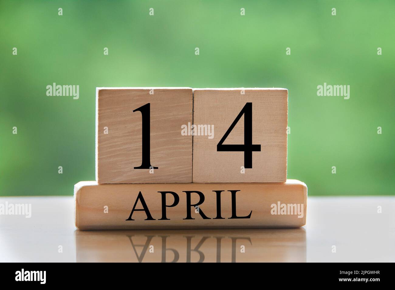 April 14 calendar date text on wooden blocks with blurred park ...