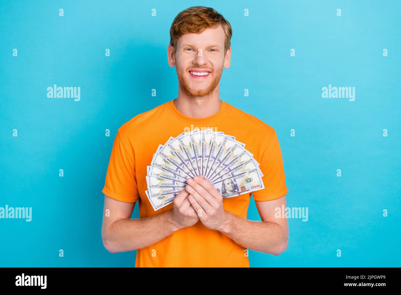Photo of hooray red hair guy hold money wear orange t-shirt isolated on ...