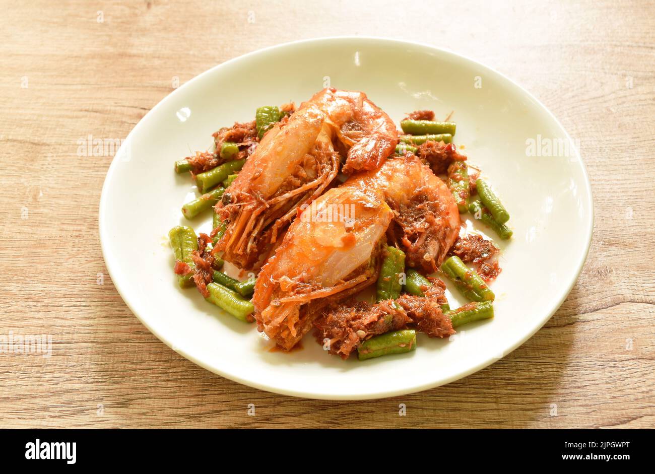 fried river shrimp with slice yard long bean in curry sauce on plate ...
