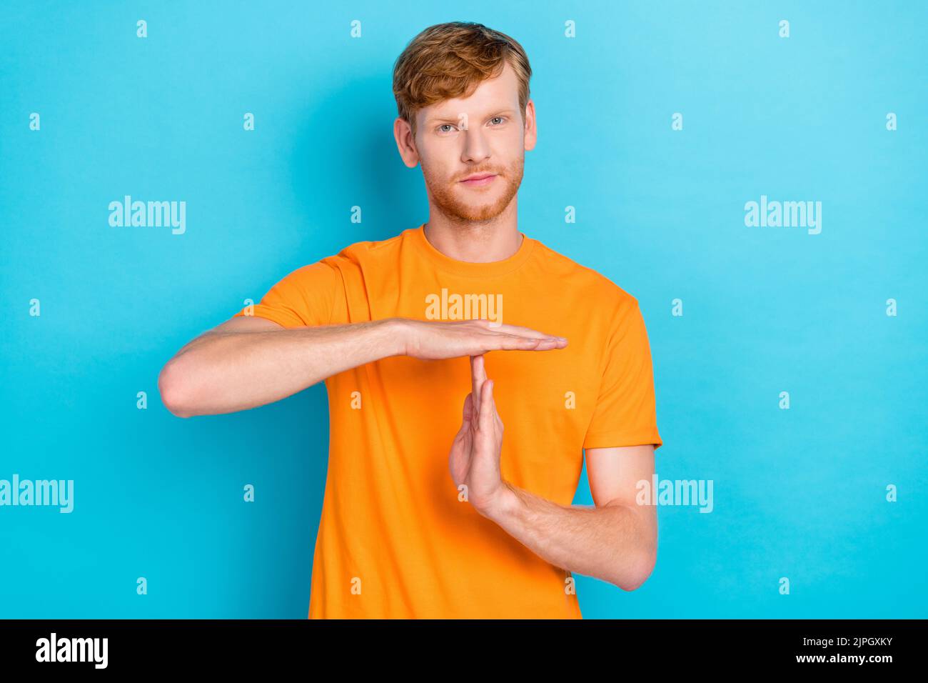 Photo of strict red hair guy pause wear orange t-shirt isolated on teal ...