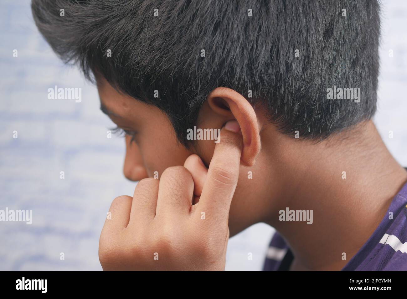 teenage boy having ear pain touching his painful ear Stock Photo - Alamy