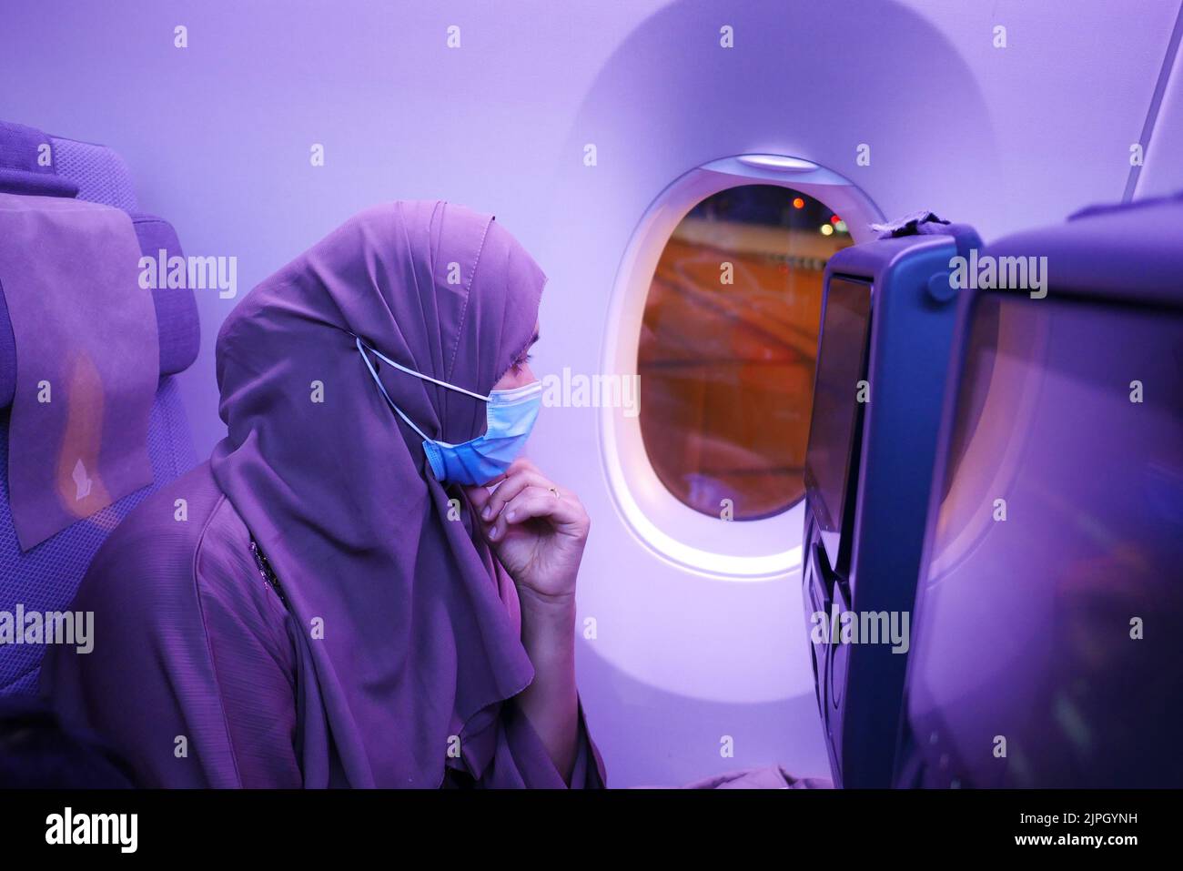women with a face mask sitting on airplane seats in the cabin Stock ...