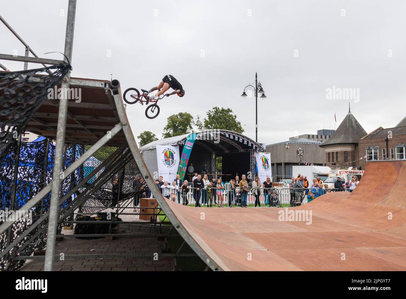 A youth on a BMX bike in mid air performing aerial stunts in a BMX ...