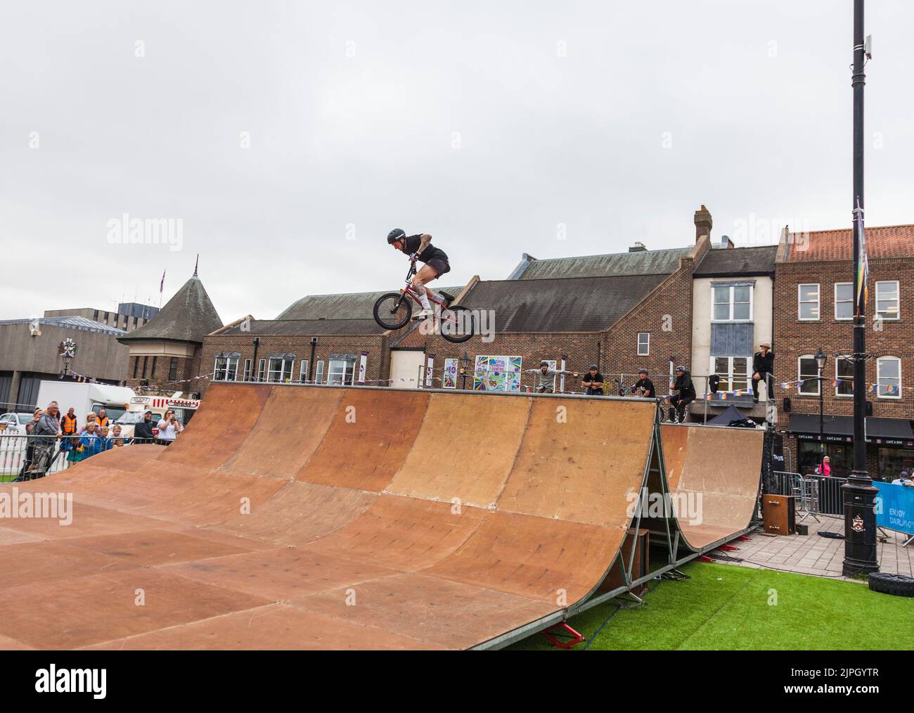 A youth on a BMX bike in mid air performing aerial stunts in a BMX ...