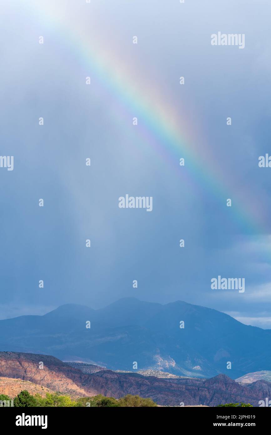 A rain storm over the La Sal Mountains with a rainbow, near Moab, Utah ...