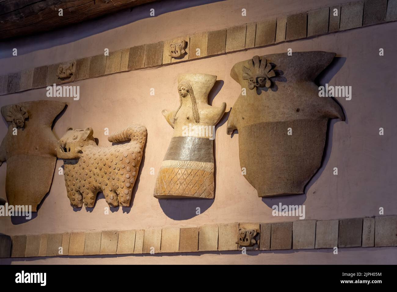 Pre-Hispanic indigenous-style ceramic figures decorate the wall of a ...