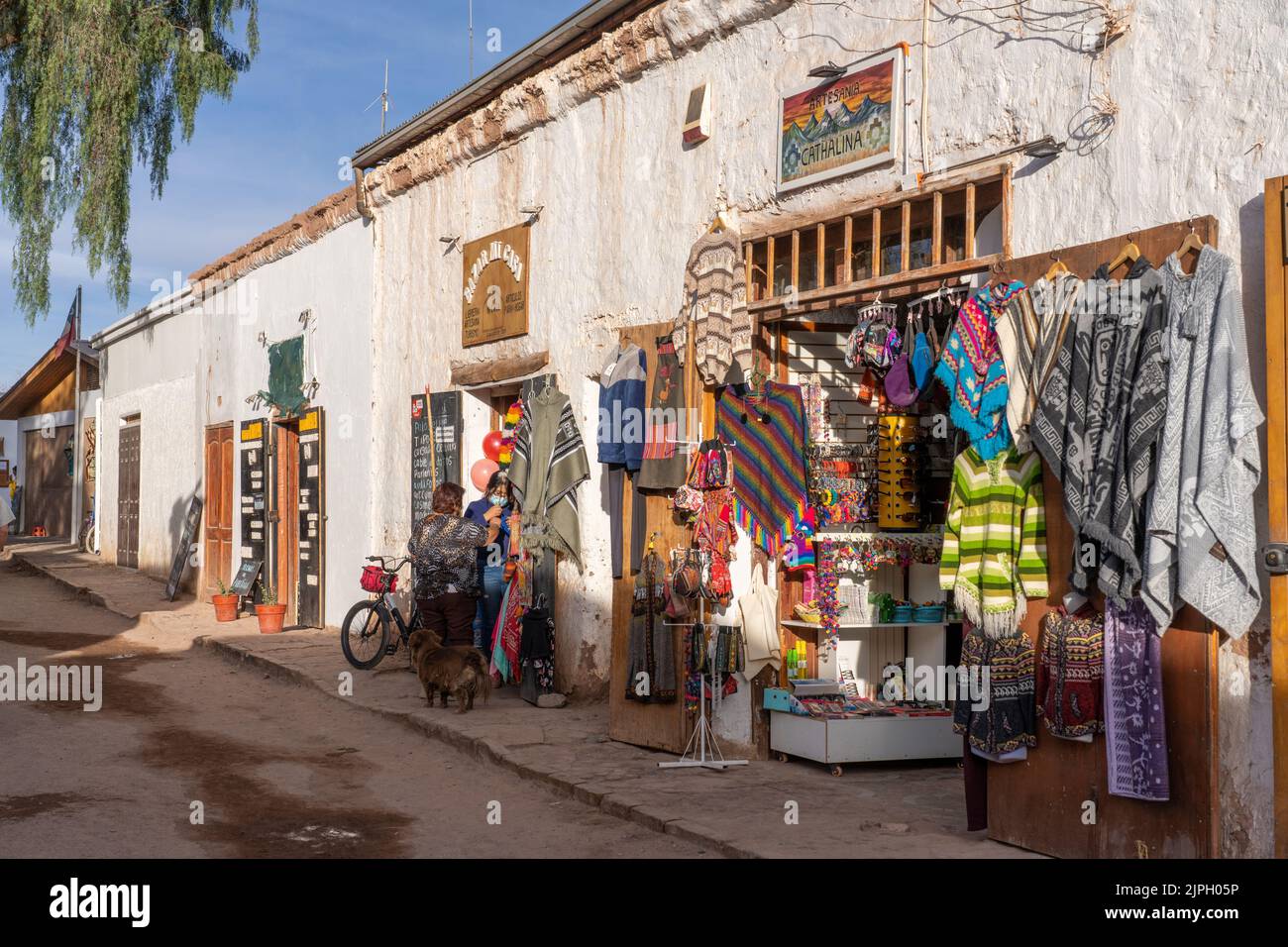 Tourist souvenir shops display hand-woven Andean weavings along a ...