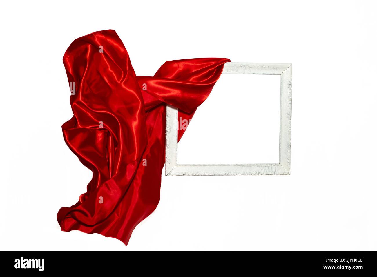 Flying red satin cloth unveiling a white vintage frame. Levitating ...