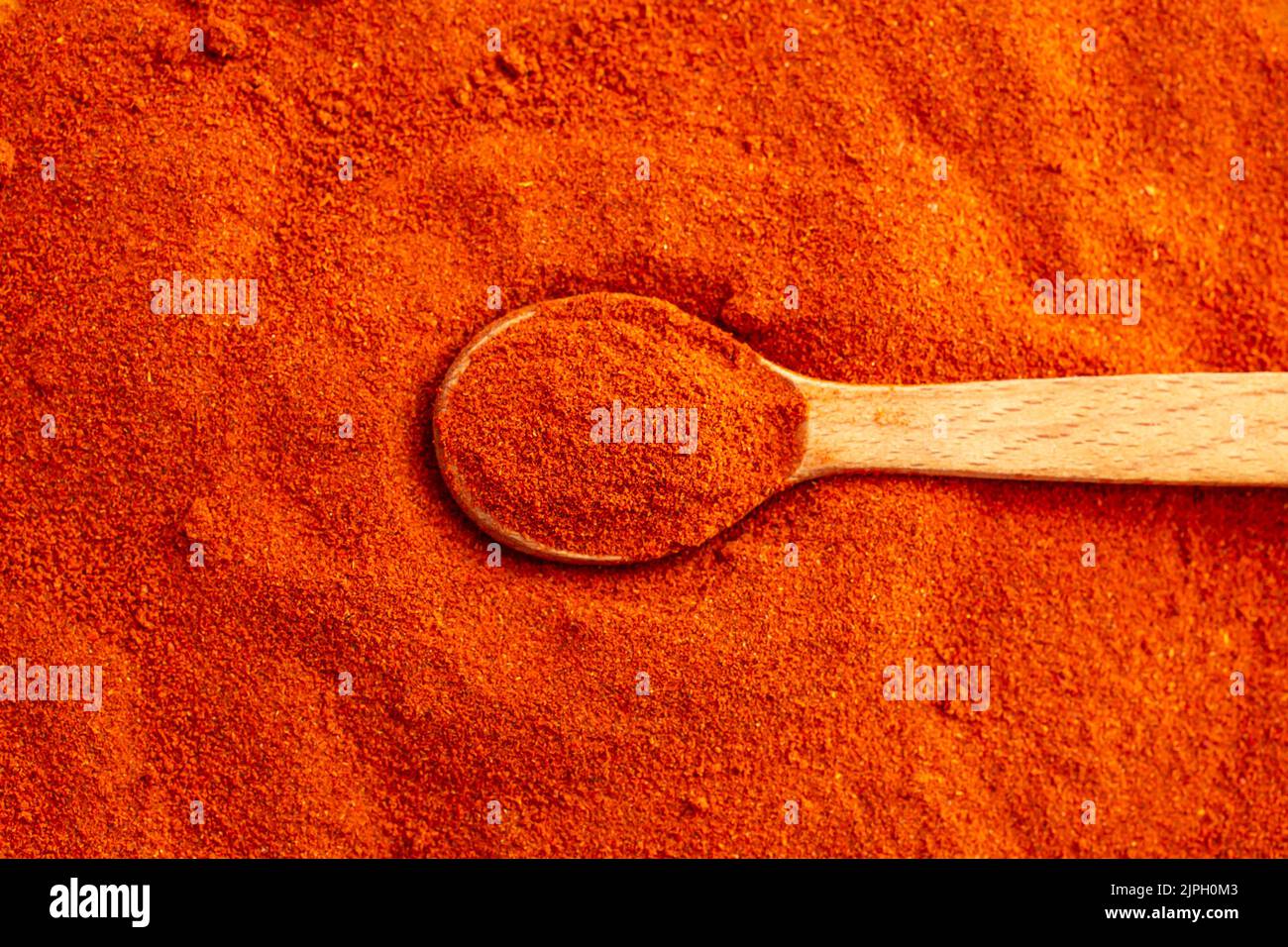 Smoked Paprika powder background, top view close up with a wooden tea ...