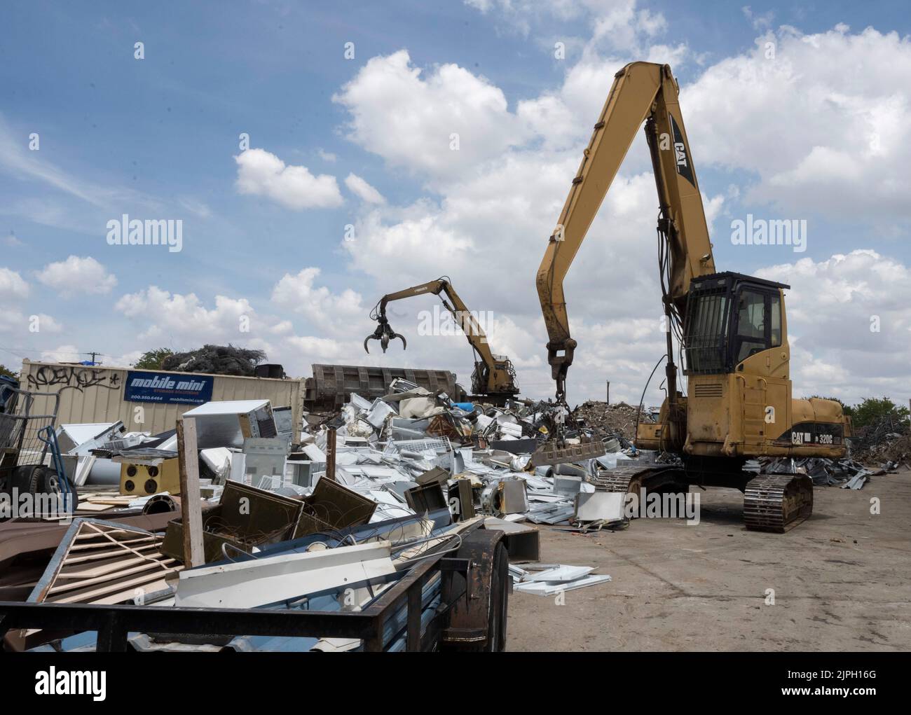 A large Caterpillar track material handler with an attached magnet ...