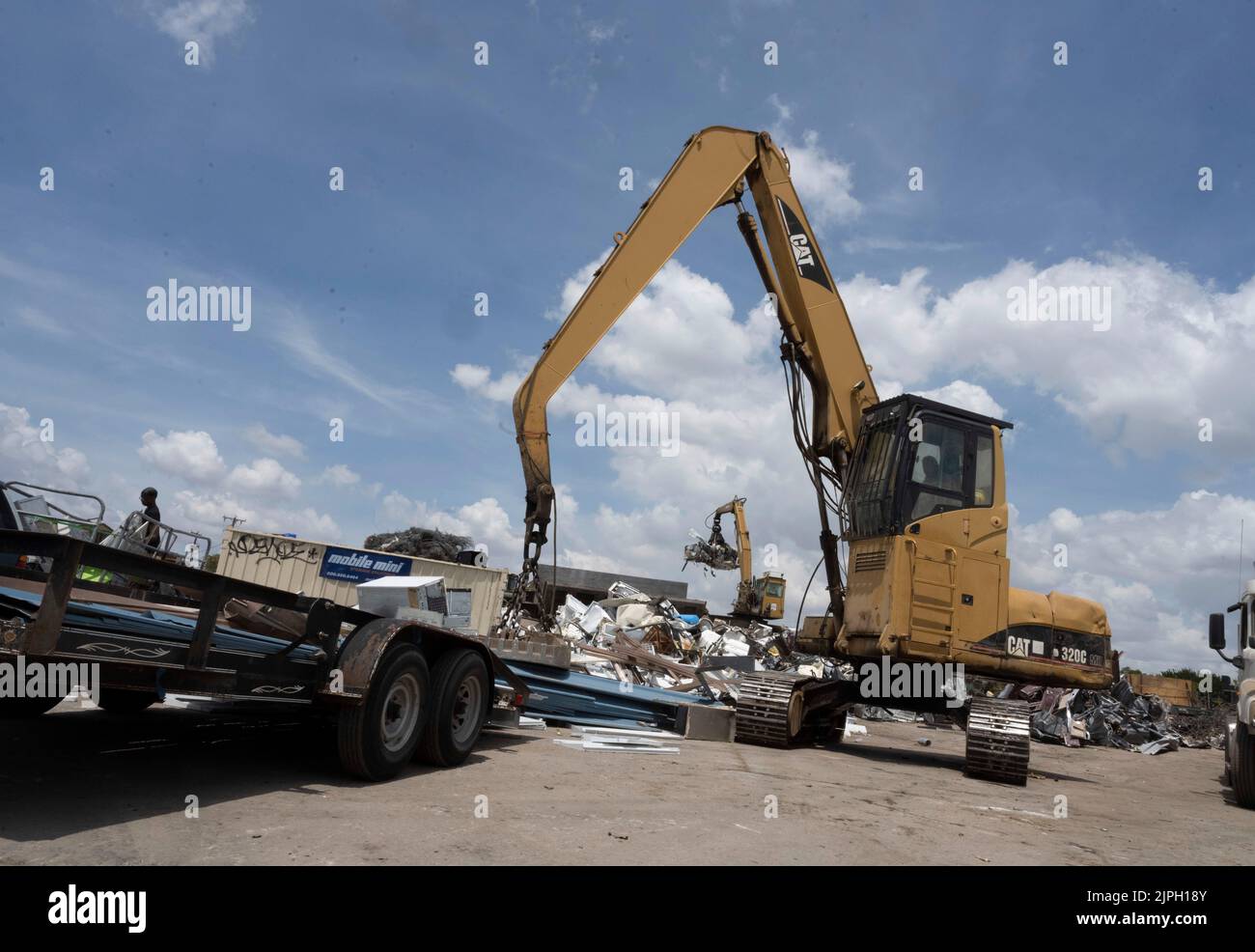 A large Caterpillar track material handler with an attached magnet ...