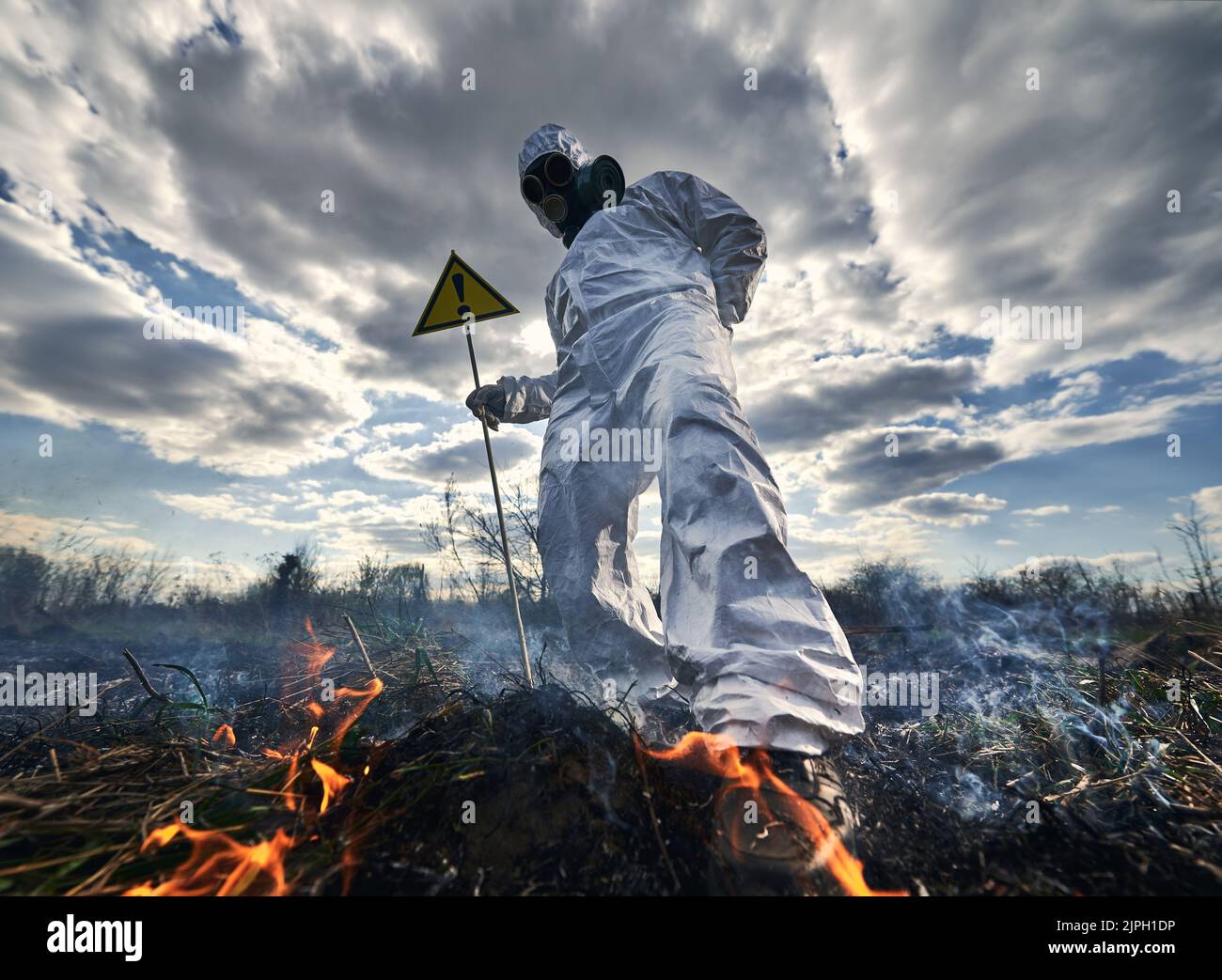 Fireman ecologist fighting fire in field. Man in protective radiation ...