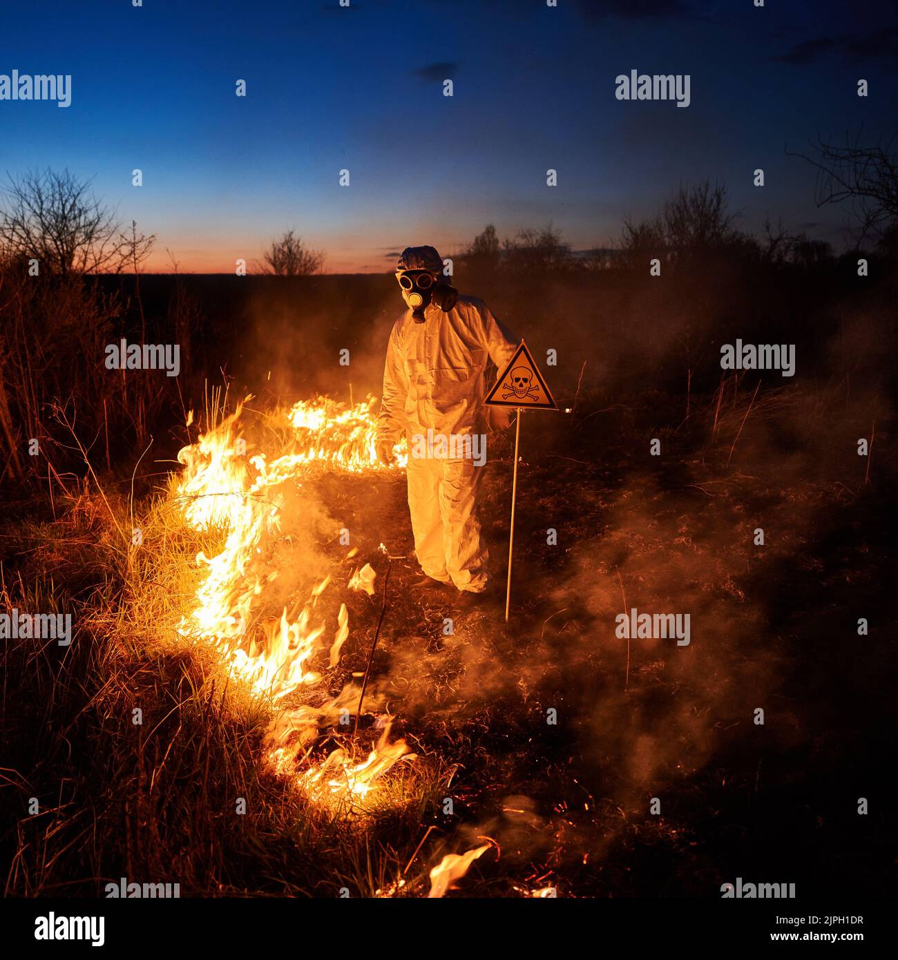 Firefighter ecologist fighting fire in field at night. Man in ...