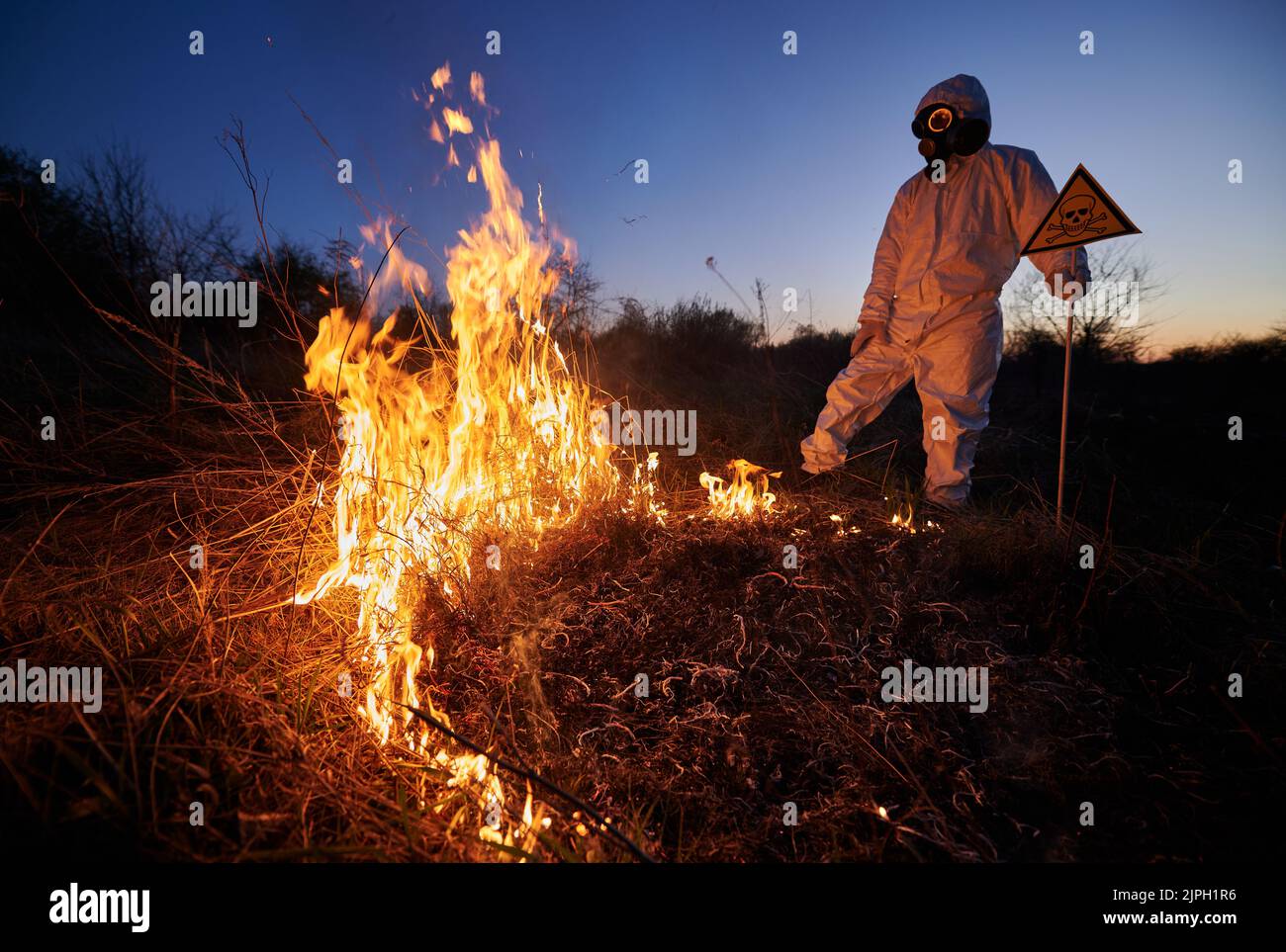 Firefighter ecologist working in field with wildfire at night. Man in ...