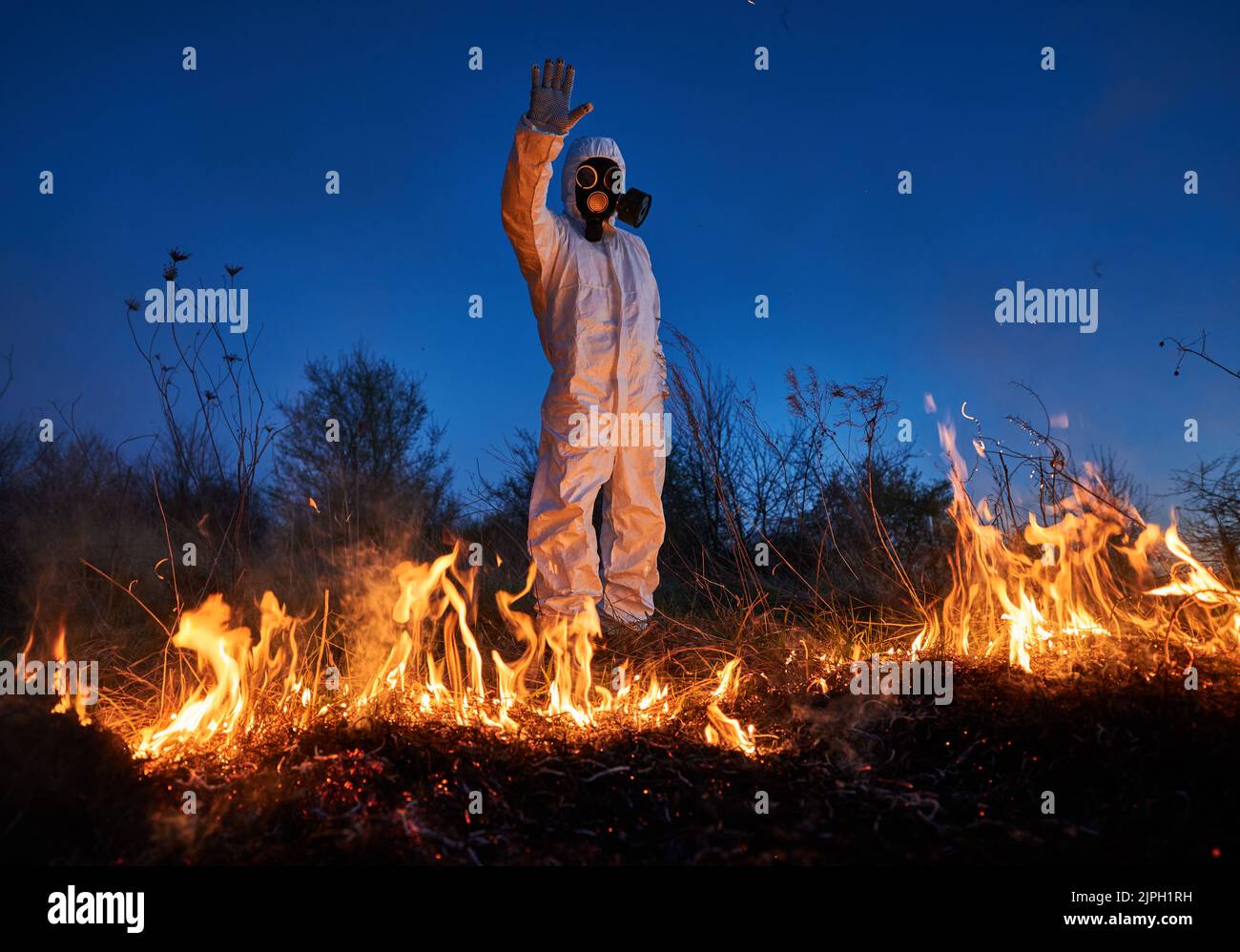 Fireman ecologist showing stop sign while working in field with ...