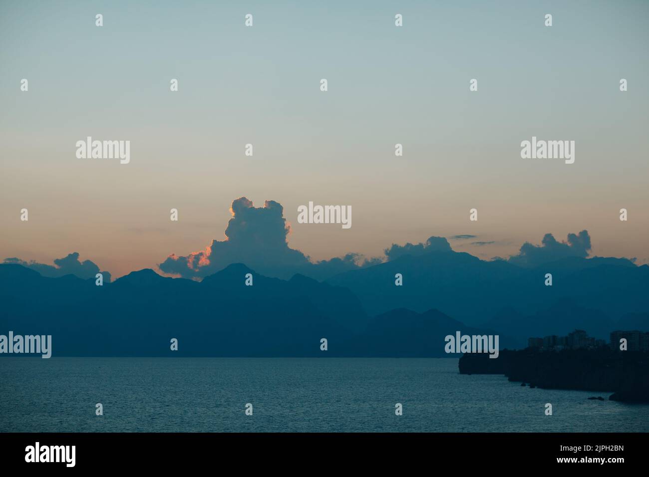 Dramatic sunset rays through cloudy dark sky over the ocean Stock Photo ...