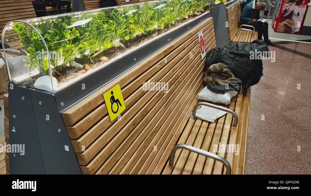 Woman tired female tourist sleeping on bench in waiting room in airport or railway station Stock ...