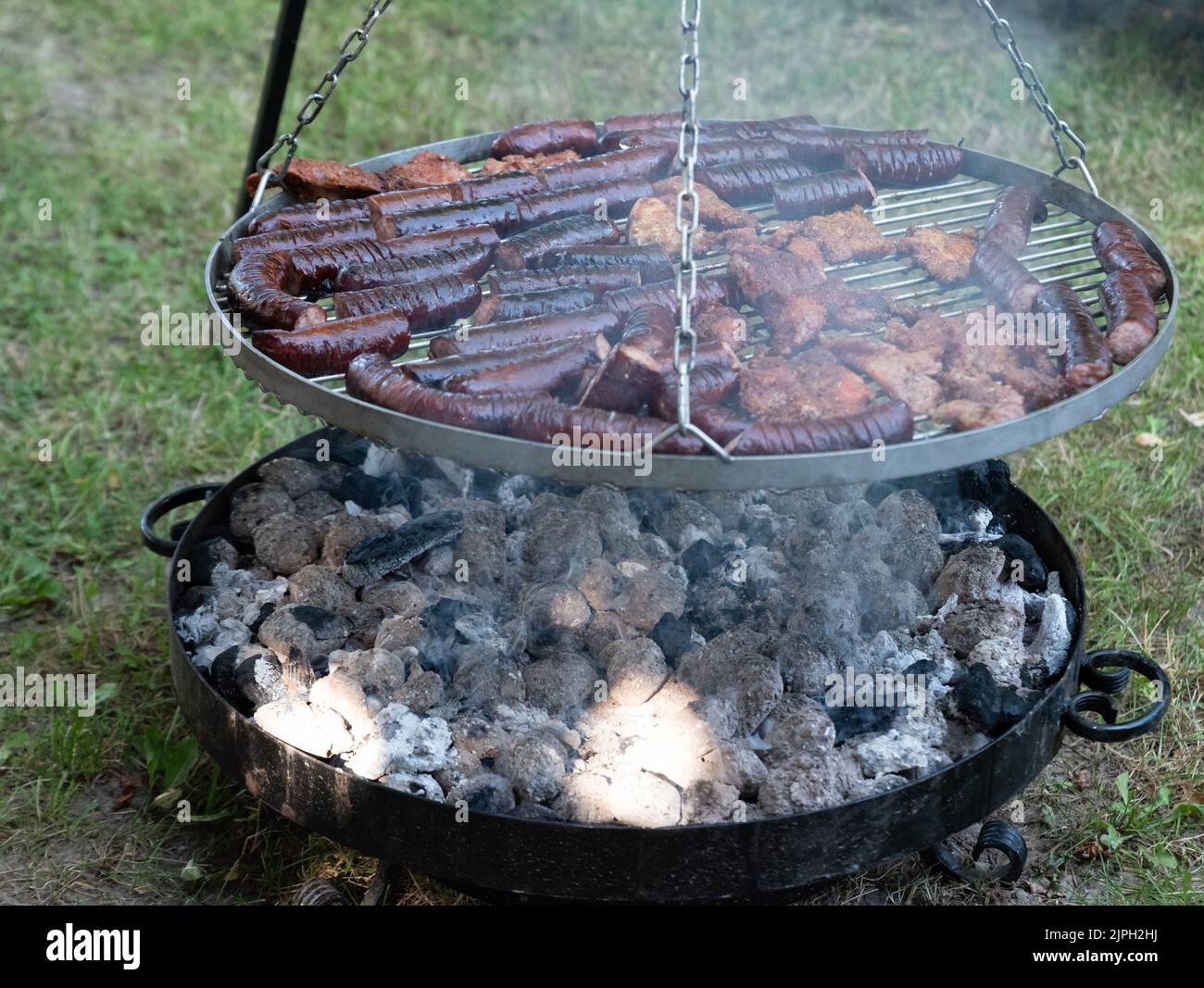 Grilling meat and sausages. Barbecue in the garden, hot coals in the ...