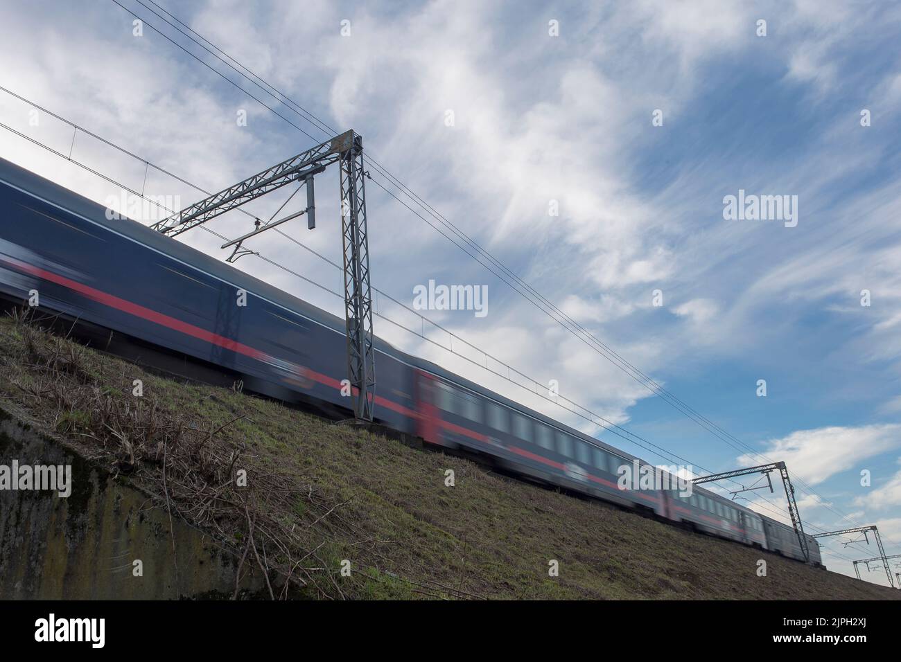 Motion blurred train passing by over a bridge in the italian country ...