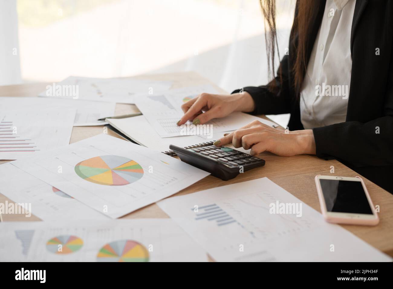 Close up business woman using calculator to do finance math on wooden ...