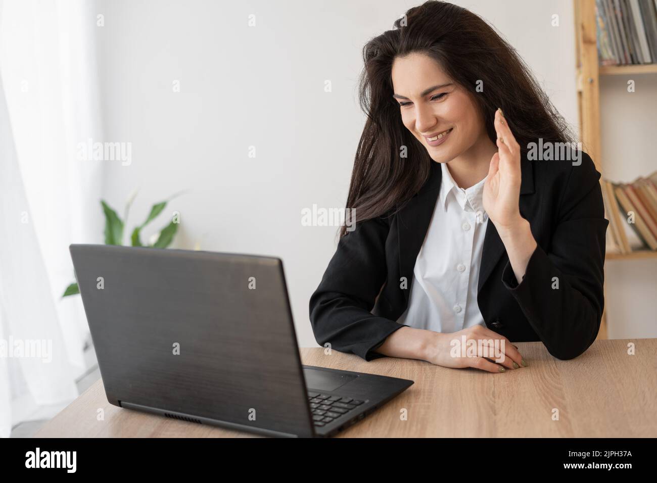 Image of a beautiful brunette woman posing sitting indoors office using ...