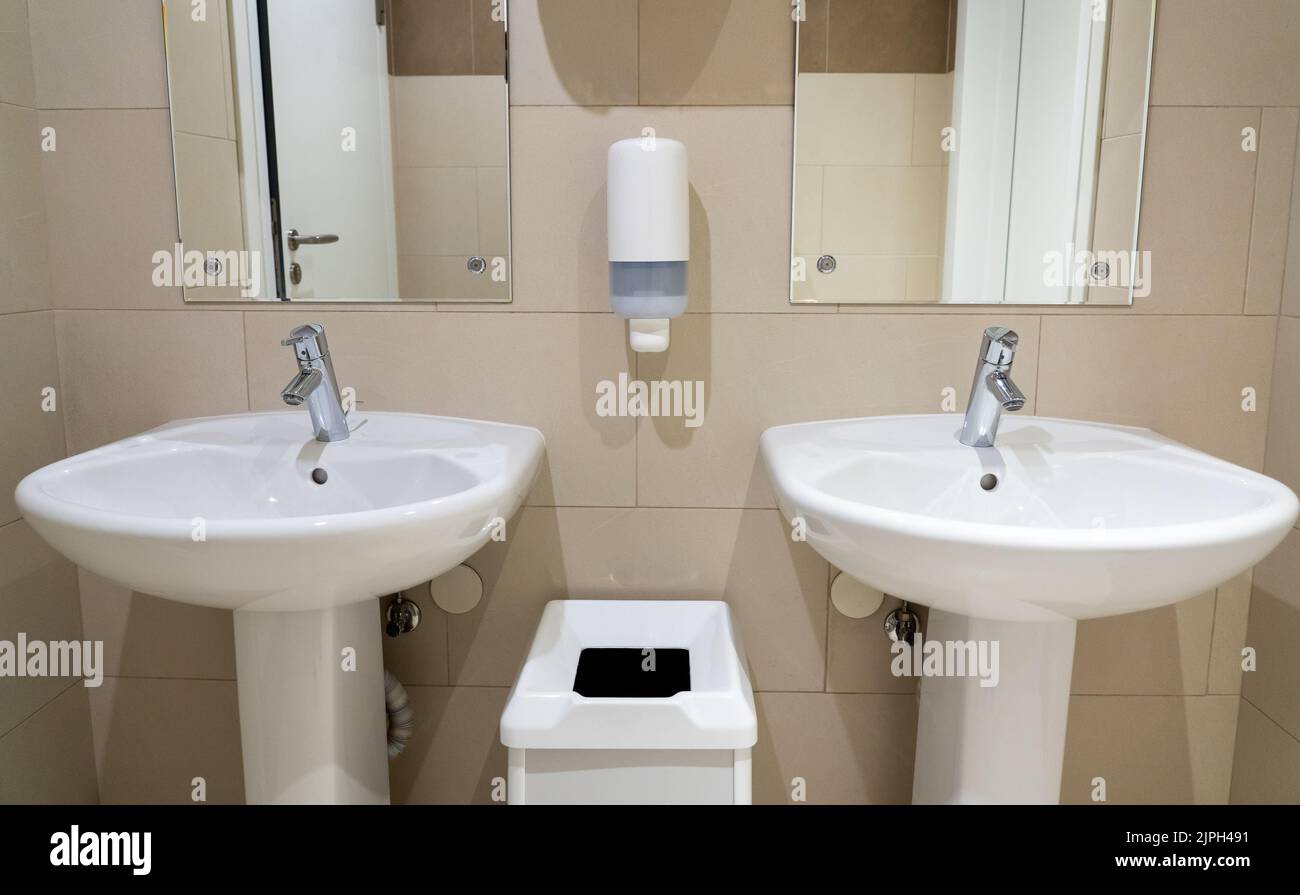 Pair of sinks in a modern public toilet with soap dishes Stock Photo ...