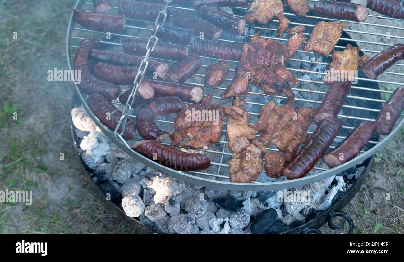 Grilling meat and sausages. Barbecue in the garden, hot coals in the ...
