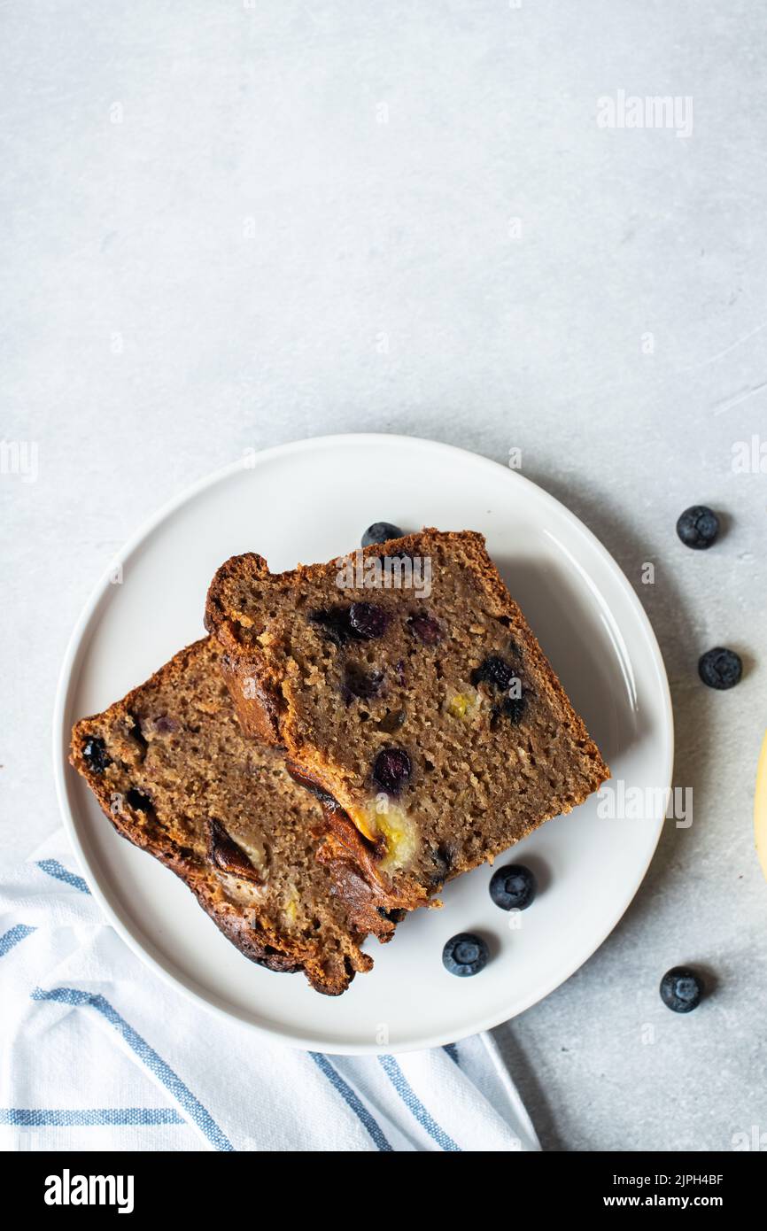Slices of banana bread with blueberries served on a plate on a gray ...