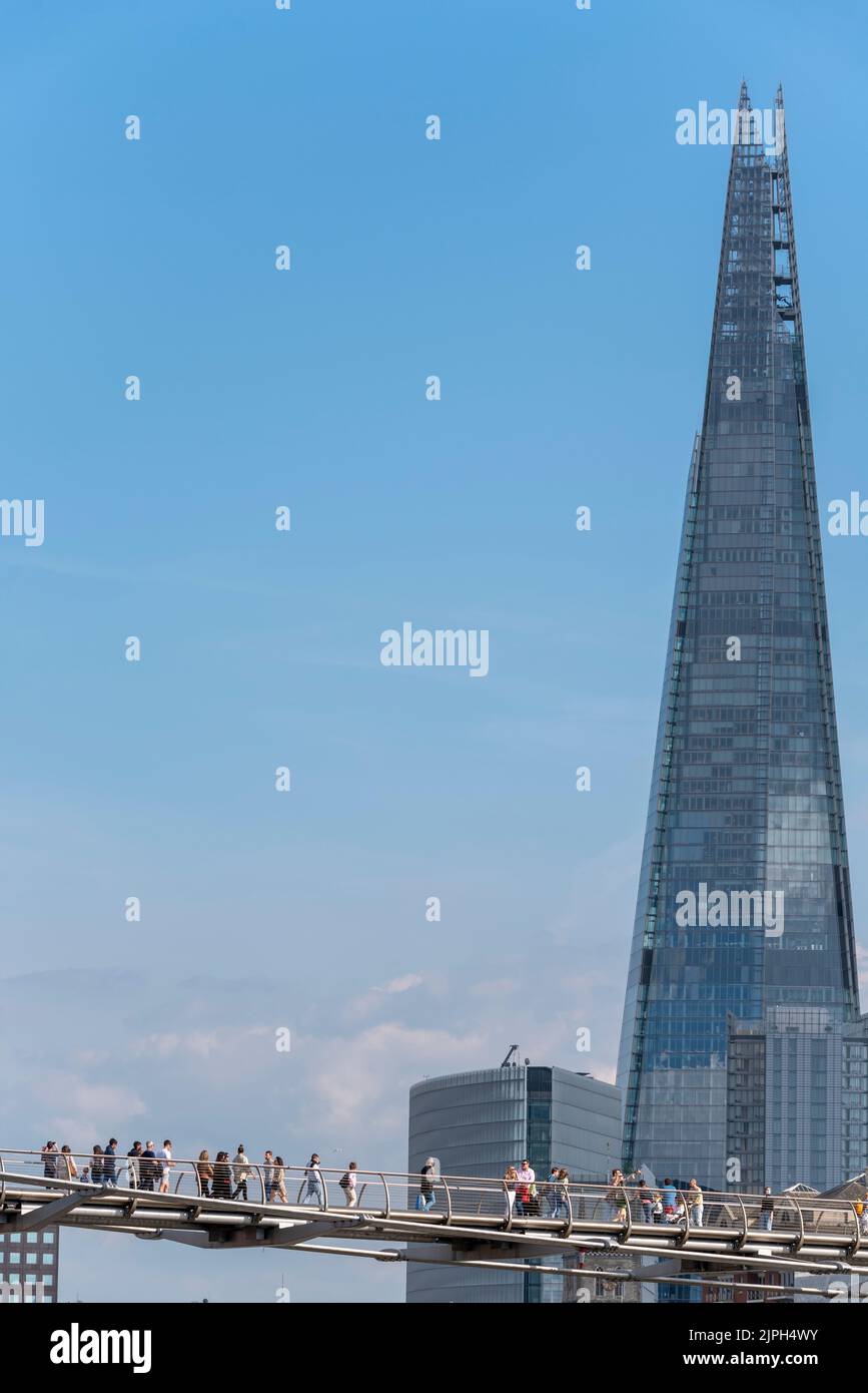 People walking across the Millennium Bridge over the River Thames ...