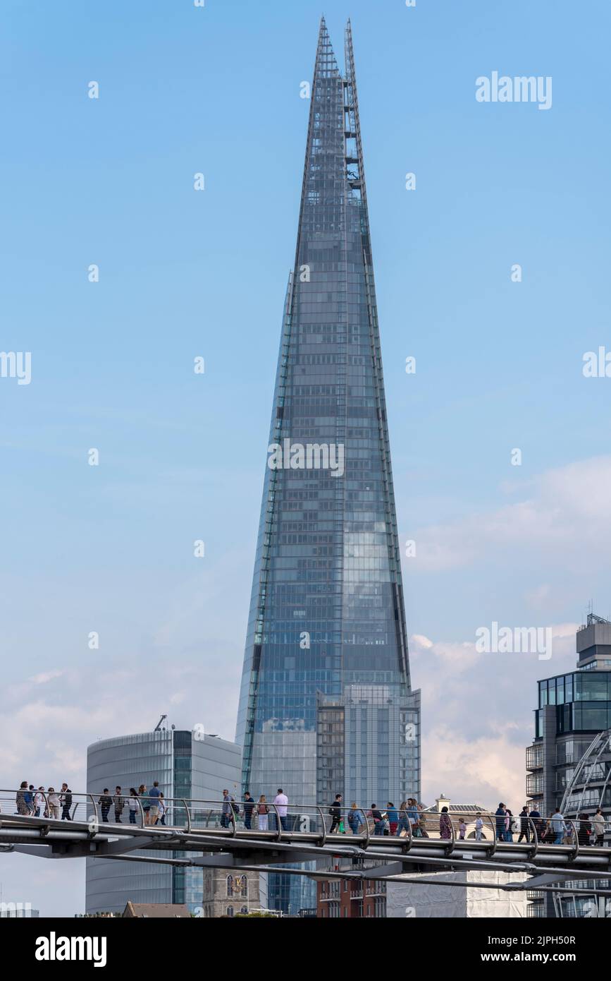People walking across the Millennium Bridge over the River Thames ...