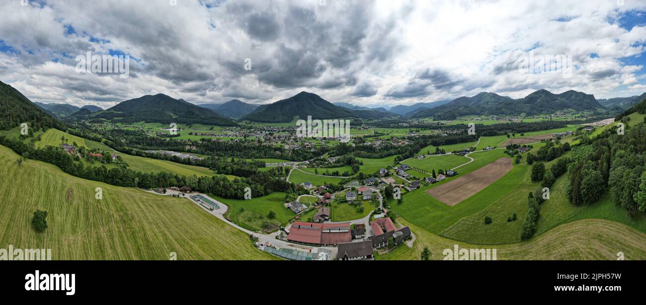 An aerial panoramic shot of a hillside with forest and houses in the ...