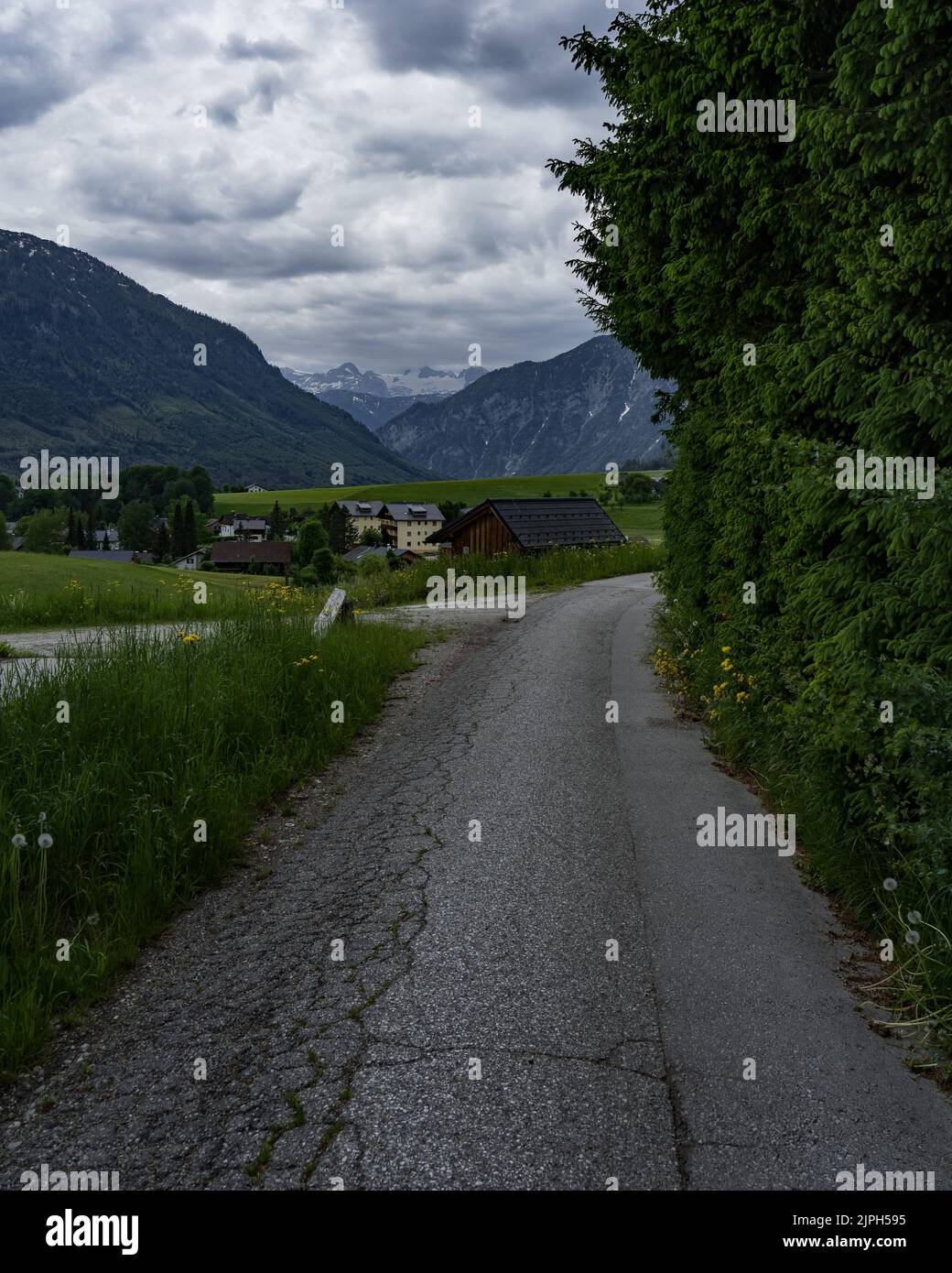 A vertical shot of a road to the countryside with houses against the ...
