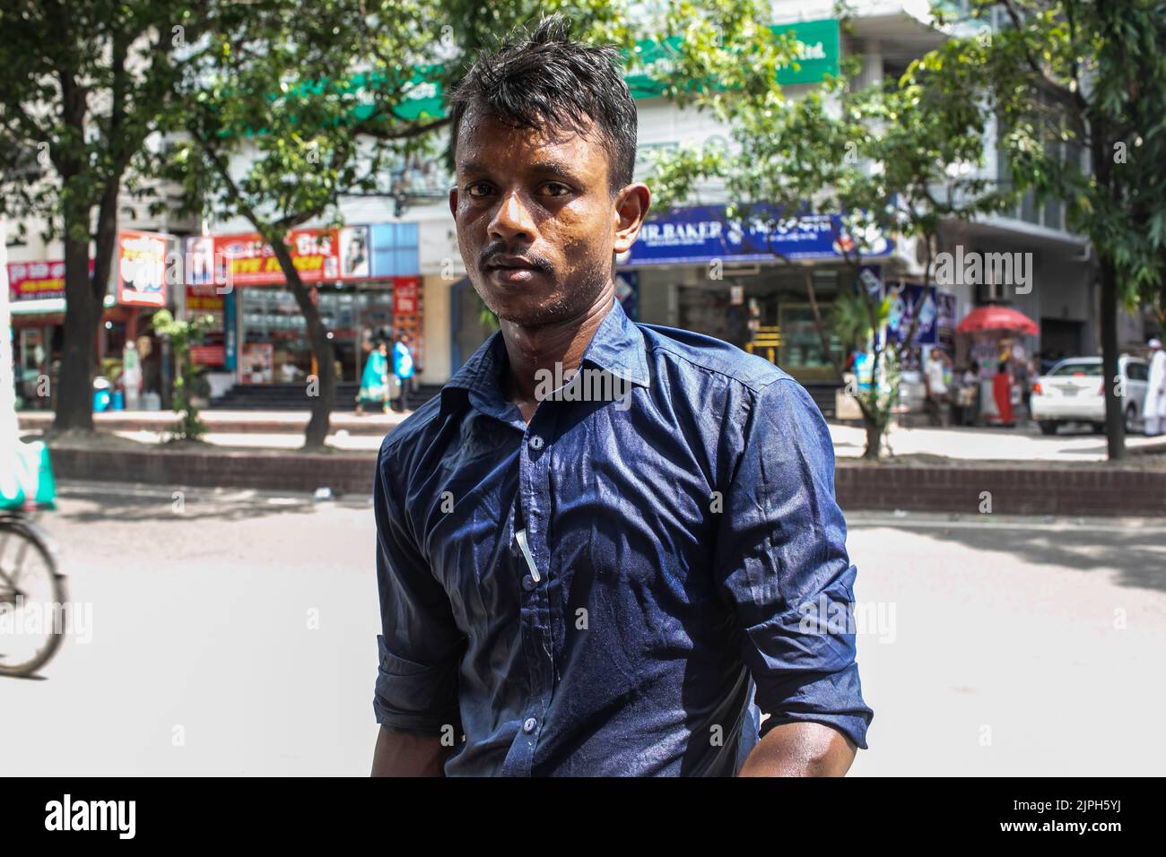 A man all sweating poses for a photo in the Street during the warm weather in Dhaka Stock Photo ...