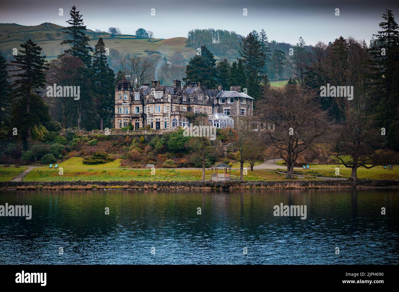 A mansion on the shore of Lake District in England surrounded by ...